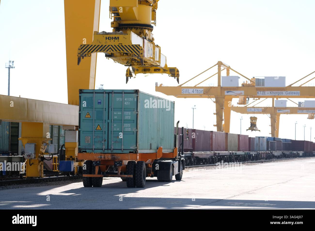 Unloading containers at the logistics center. Machines and cranes drag ...
