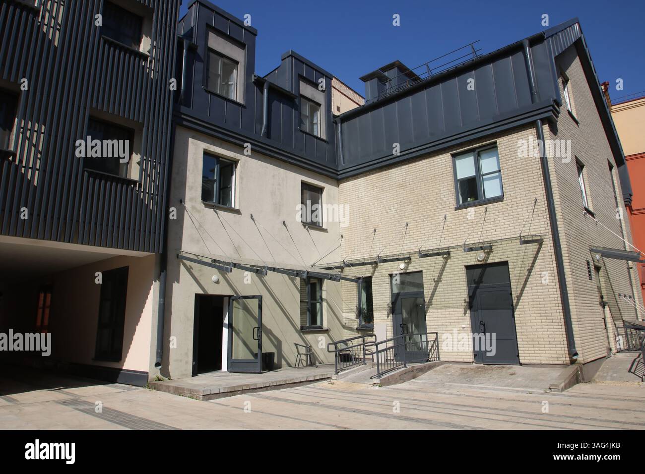 A sturdy brick building featuring a sleek black roof and a set of ...