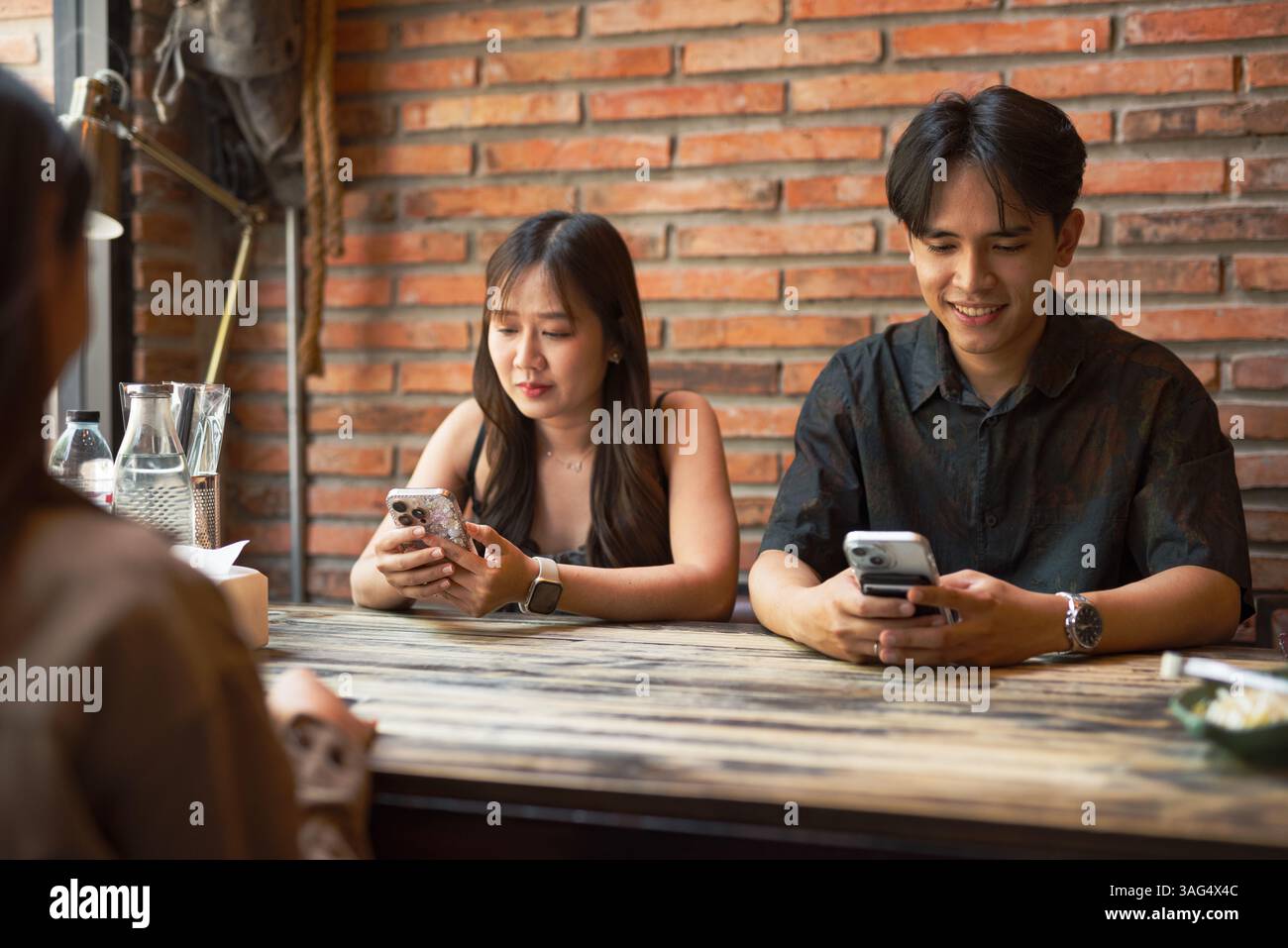 Friends eating together in restaurant and using mobile phone Stock ...