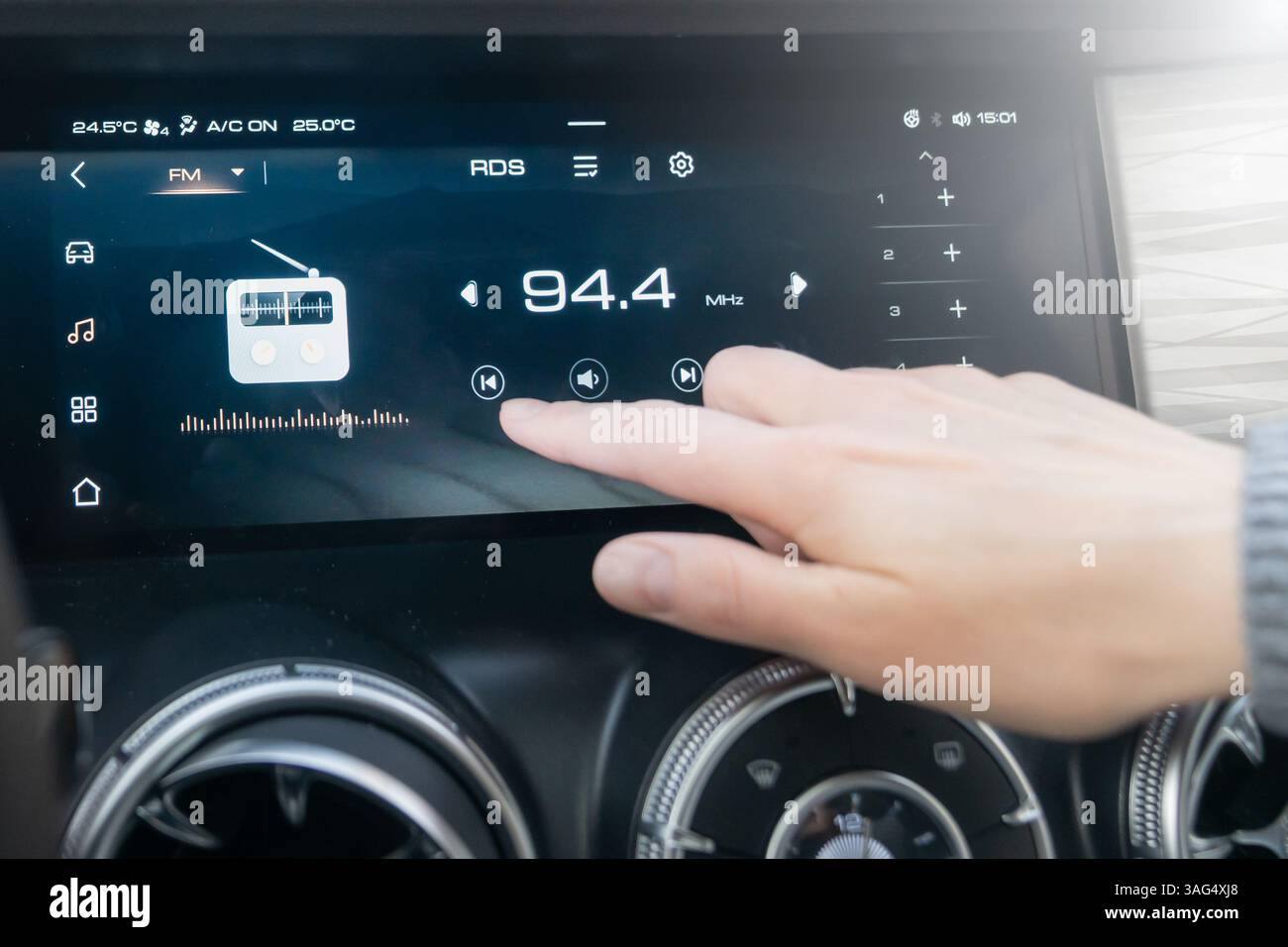 The passenger controls the radio on the car's touchscreen with his ...