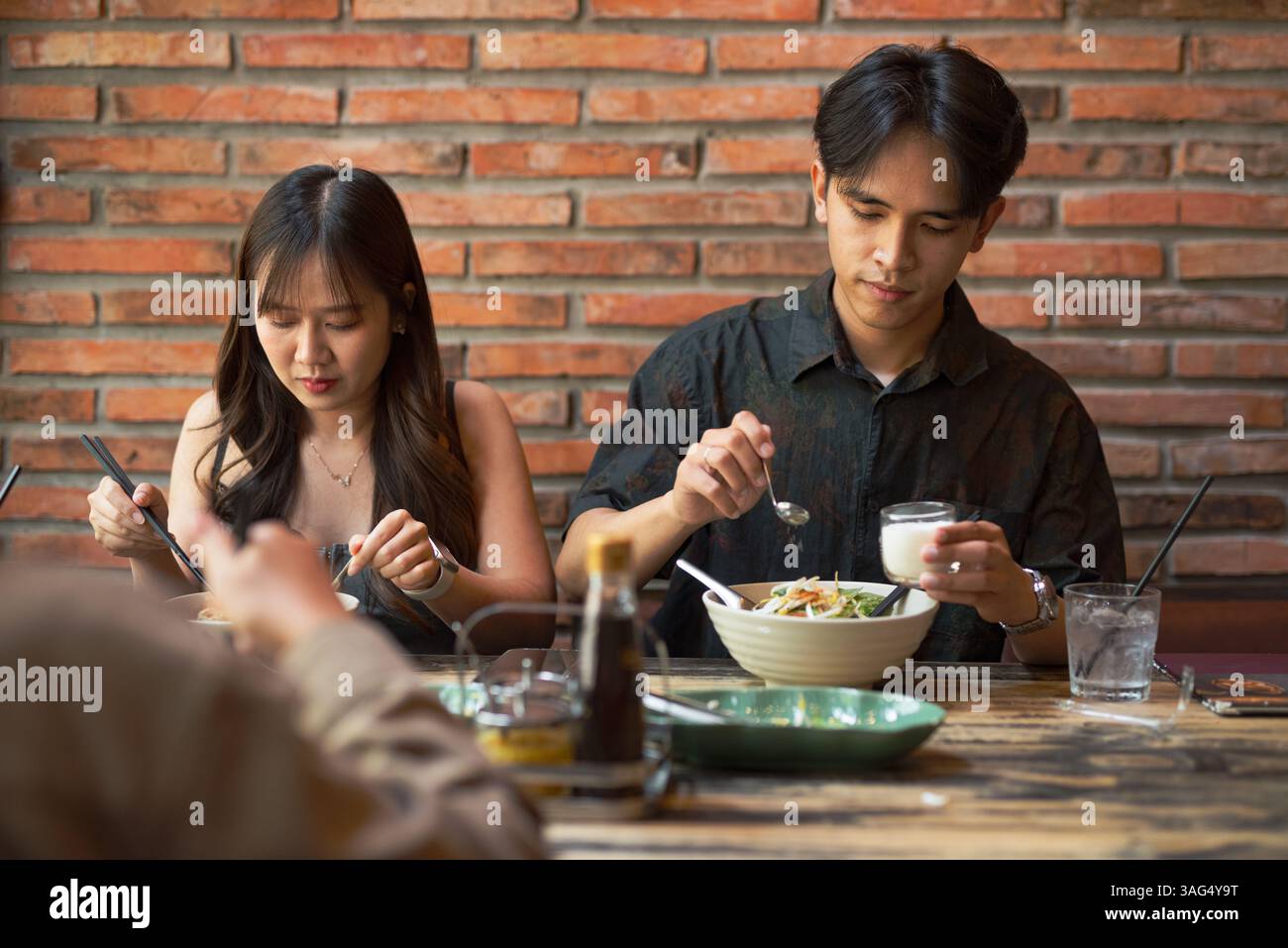 Asian friends eating together in restaurant Stock Photo - Alamy