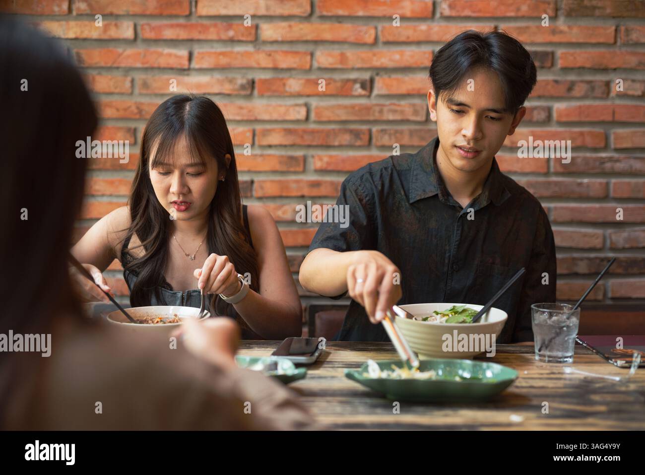 Asian friends eating together in restaurant Stock Photo - Alamy
