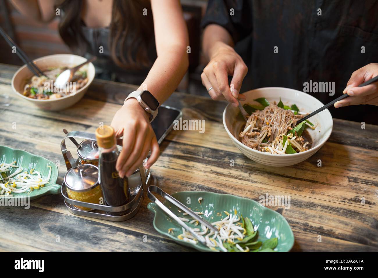Asian friends eating together in restaurant Stock Photo - Alamy