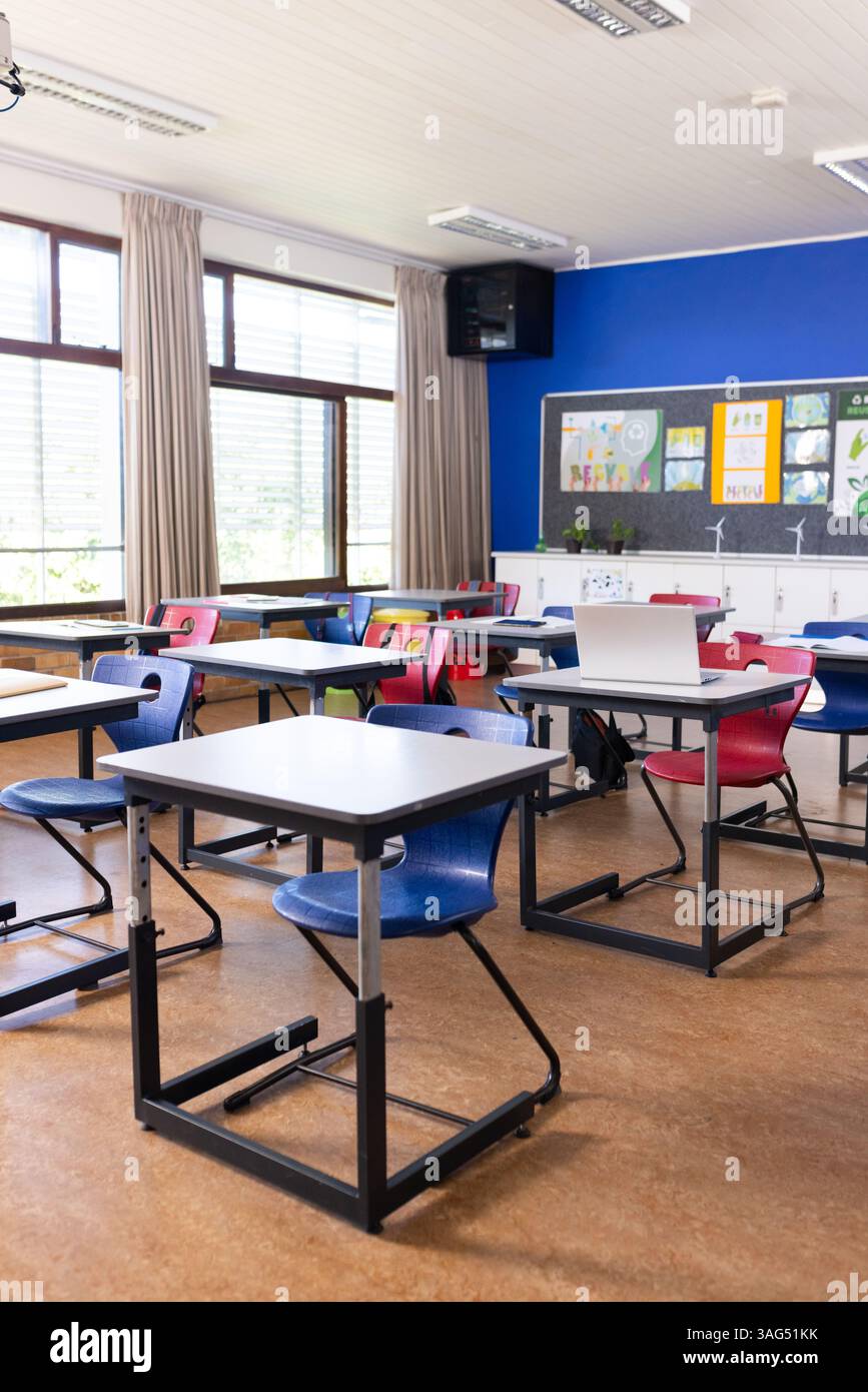 Empty classroom with colorful chairs and desks arranged neatly for ...
