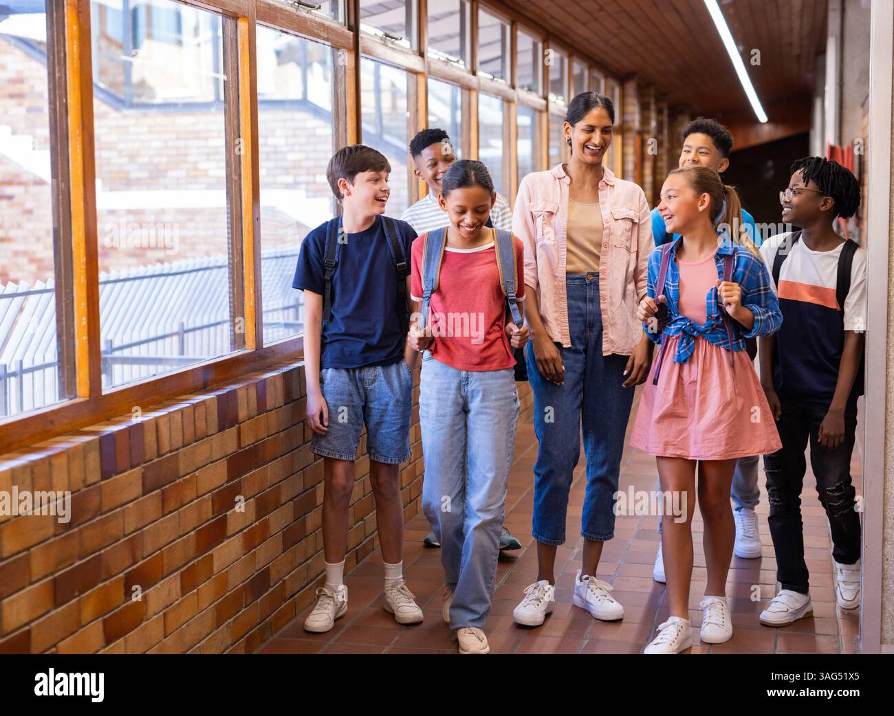 Walking in school hallway, Indian female teacher and students smiling ...