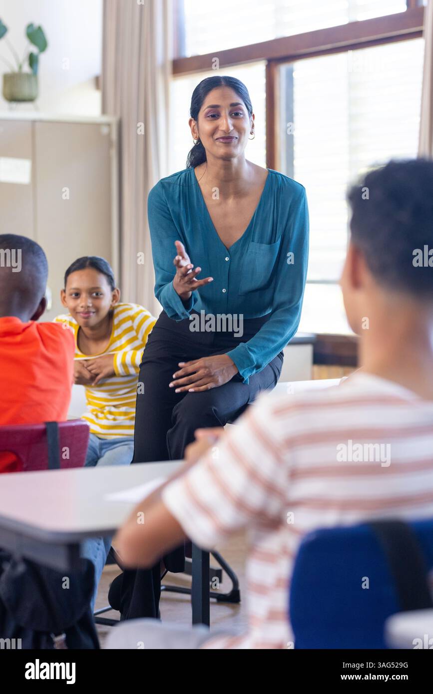 In school, Indian female teacher engaging with students, fostering interactive learning ...