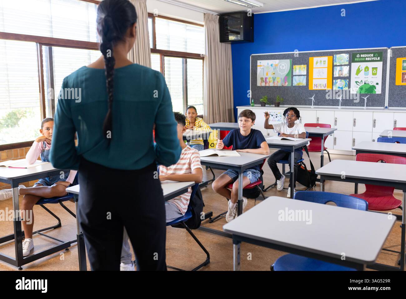 Standing in classroom, indian female teacher instructing while students ...