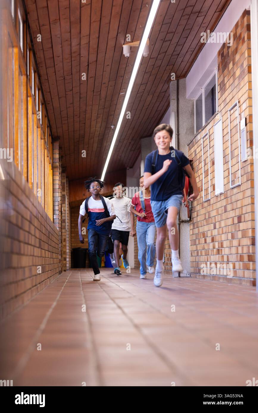 Running down hallway, group of school children enjoying break time ...