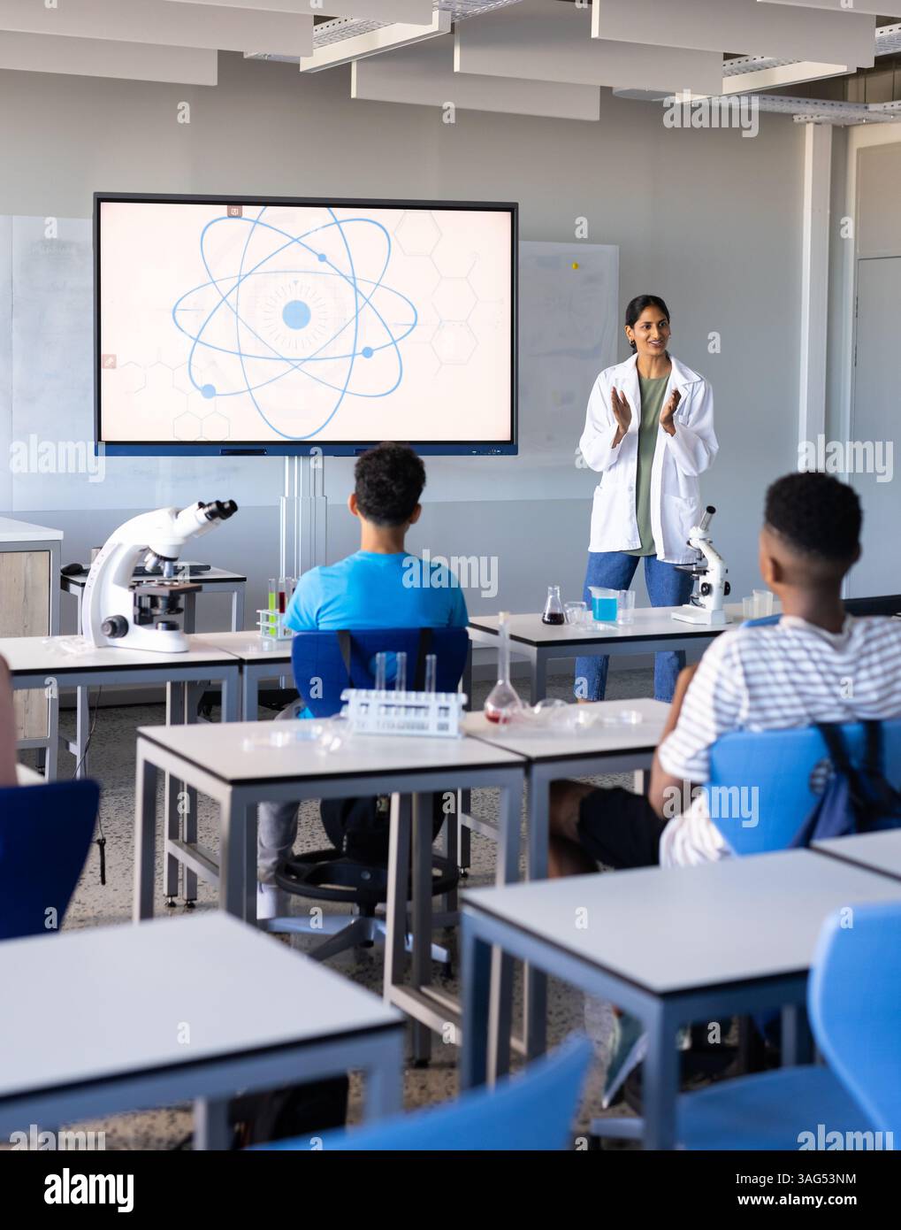 Explaining science concept in school, indian female teacher with ...