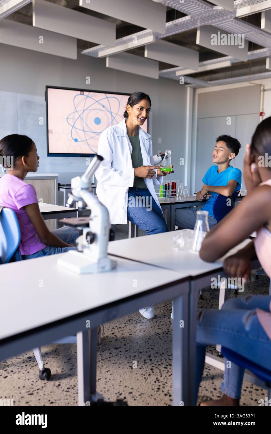 In school, Indian female teacher demonstrating science experiment to ...