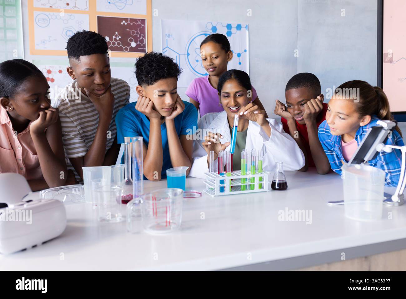 In school, students observing Indian female teacher conducting science ...