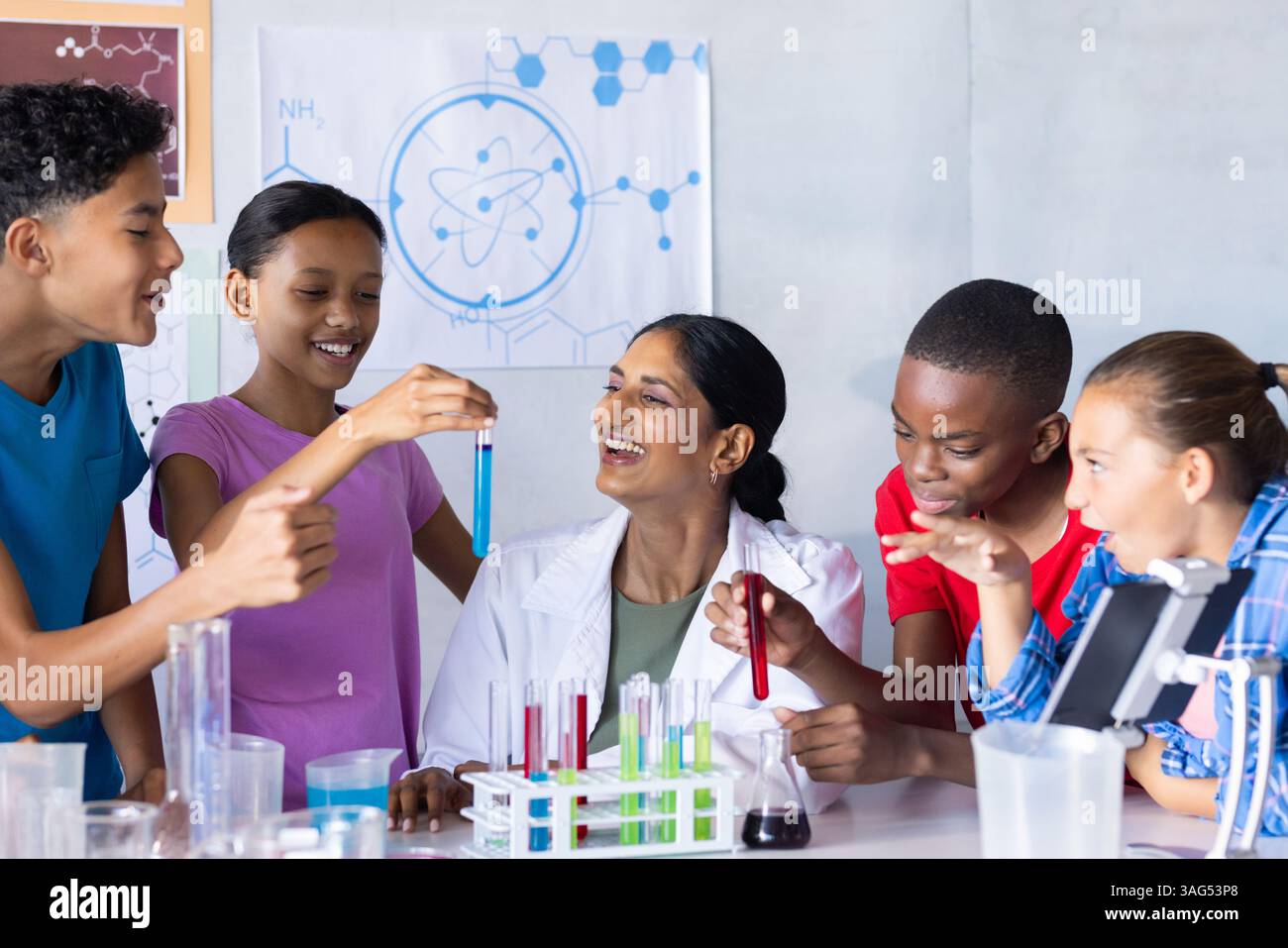 In school, students conducting science experiment with Indian female ...
