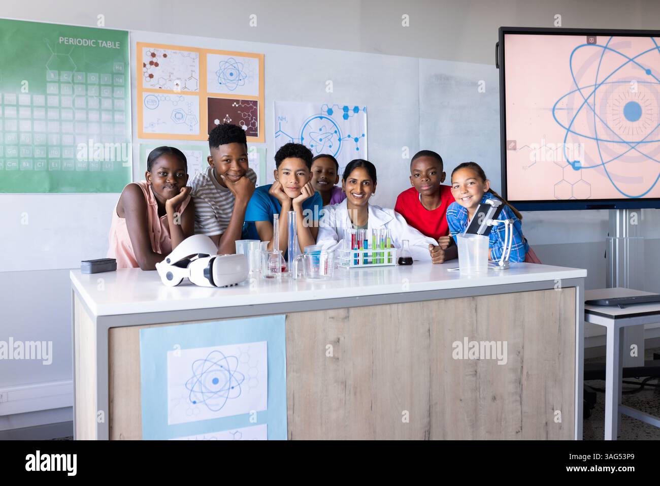 Smiling in science classroom, Indian female teacher and group of ...