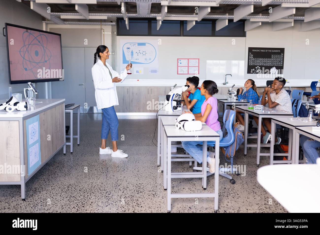 In school, indian female teacher explaining science experiment to ...