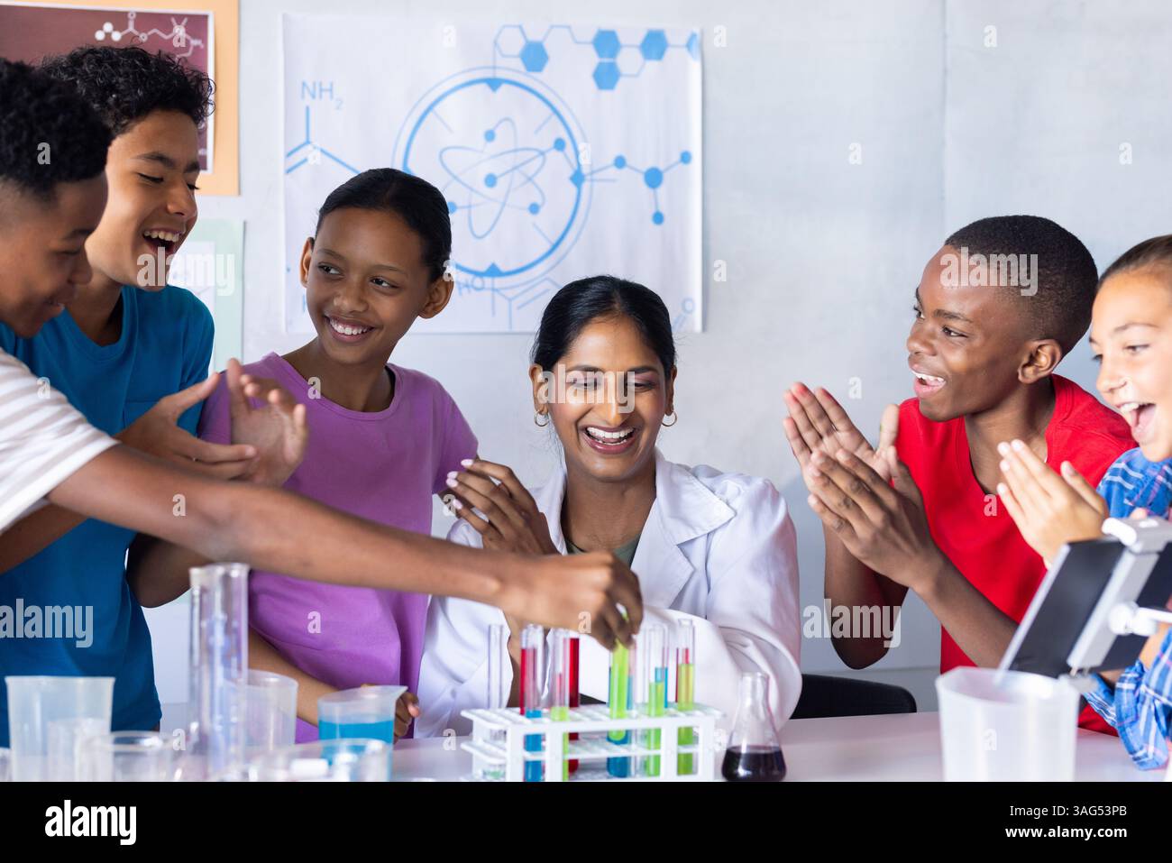 In school, students clapping and smiling with Indian female teacher in ...