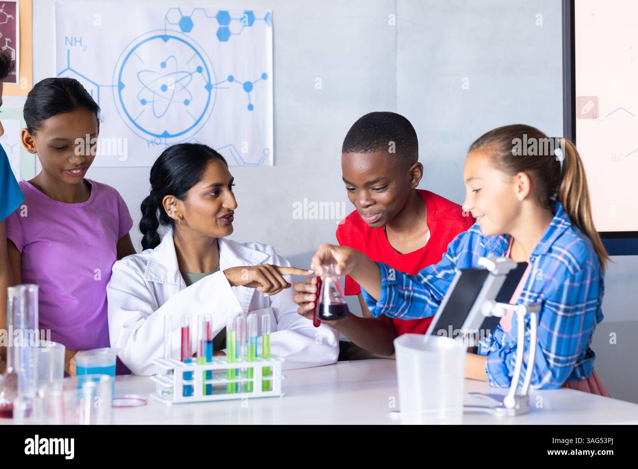 In school, Indian female teacher and students conducting science ...