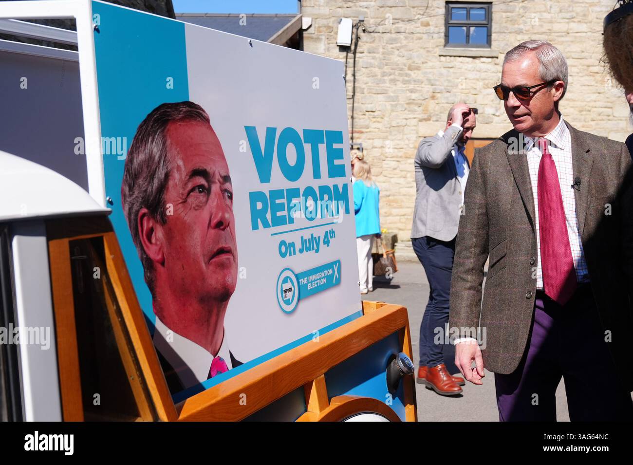 Reform UK leader Nigel Farage looking at a poster, whilst on the local ...