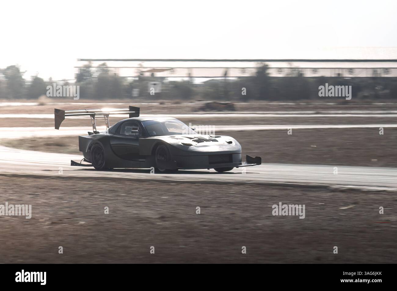 Gray sports car powering through sharp turn during competitive race ...