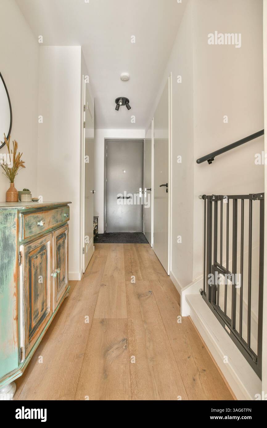 A contemporary hallway featuring a wooden floor, stylish decor, and an ...