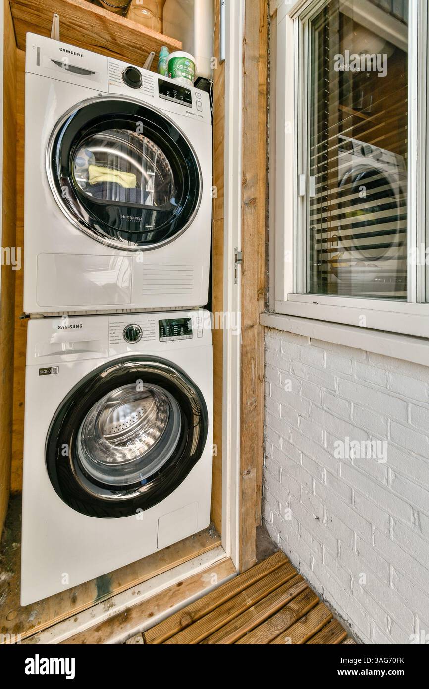 A well-organized laundry area featuring a stackable washer and dryer ...