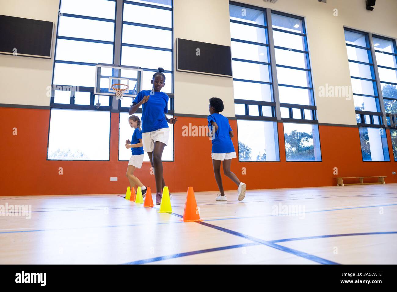 Running through cones, diverse girls participating in physical ...