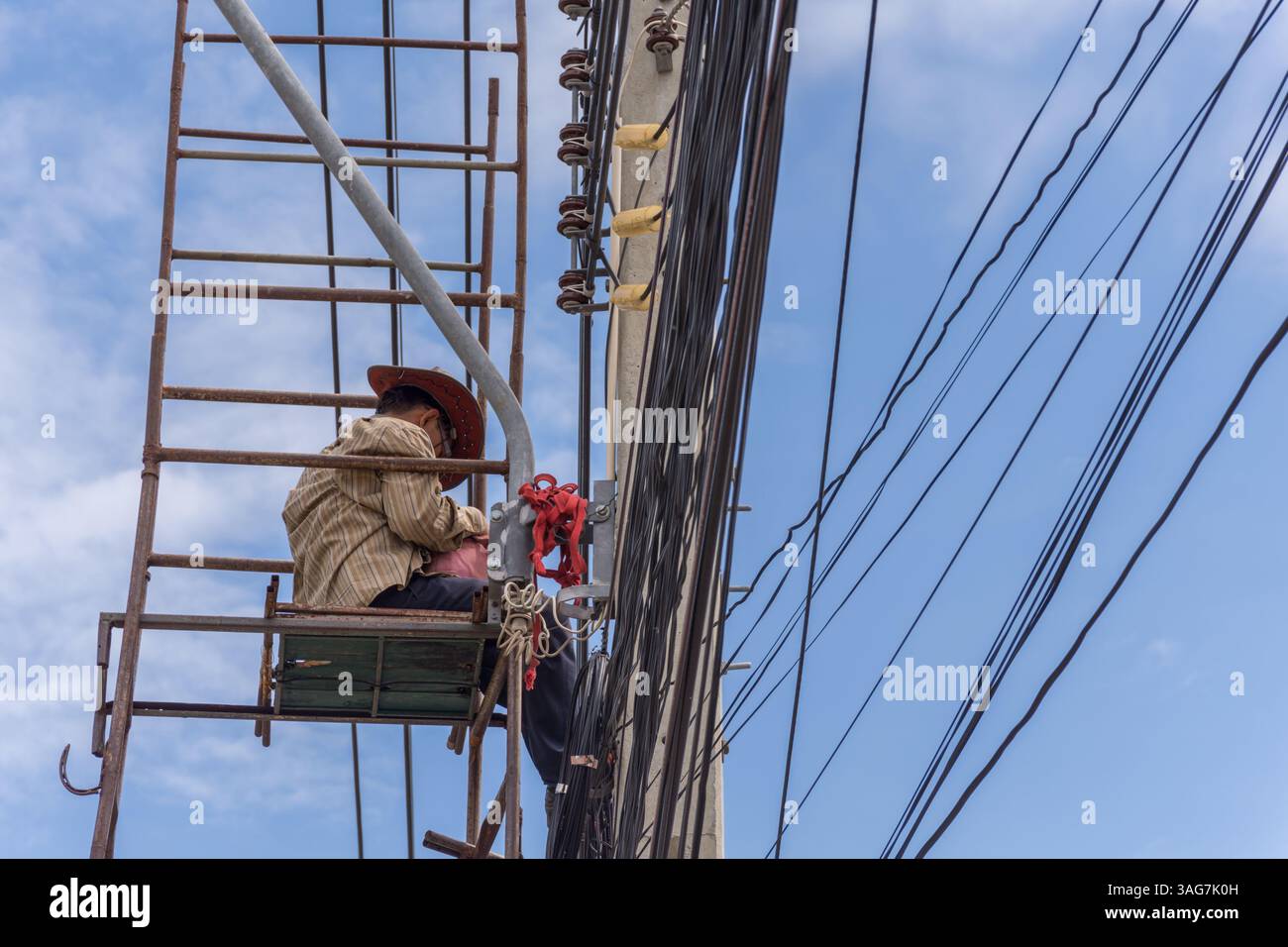 Worker working to install electric line by scaffolding on pickup truck ...
