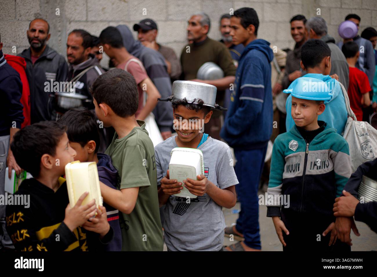 Palestinians gather in large numbers to receive the meals distributed ...
