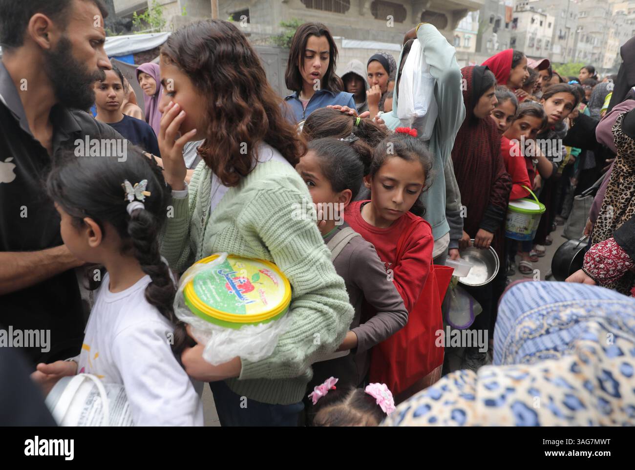 Palestinians gather in large numbers to receive the meals distributed ...