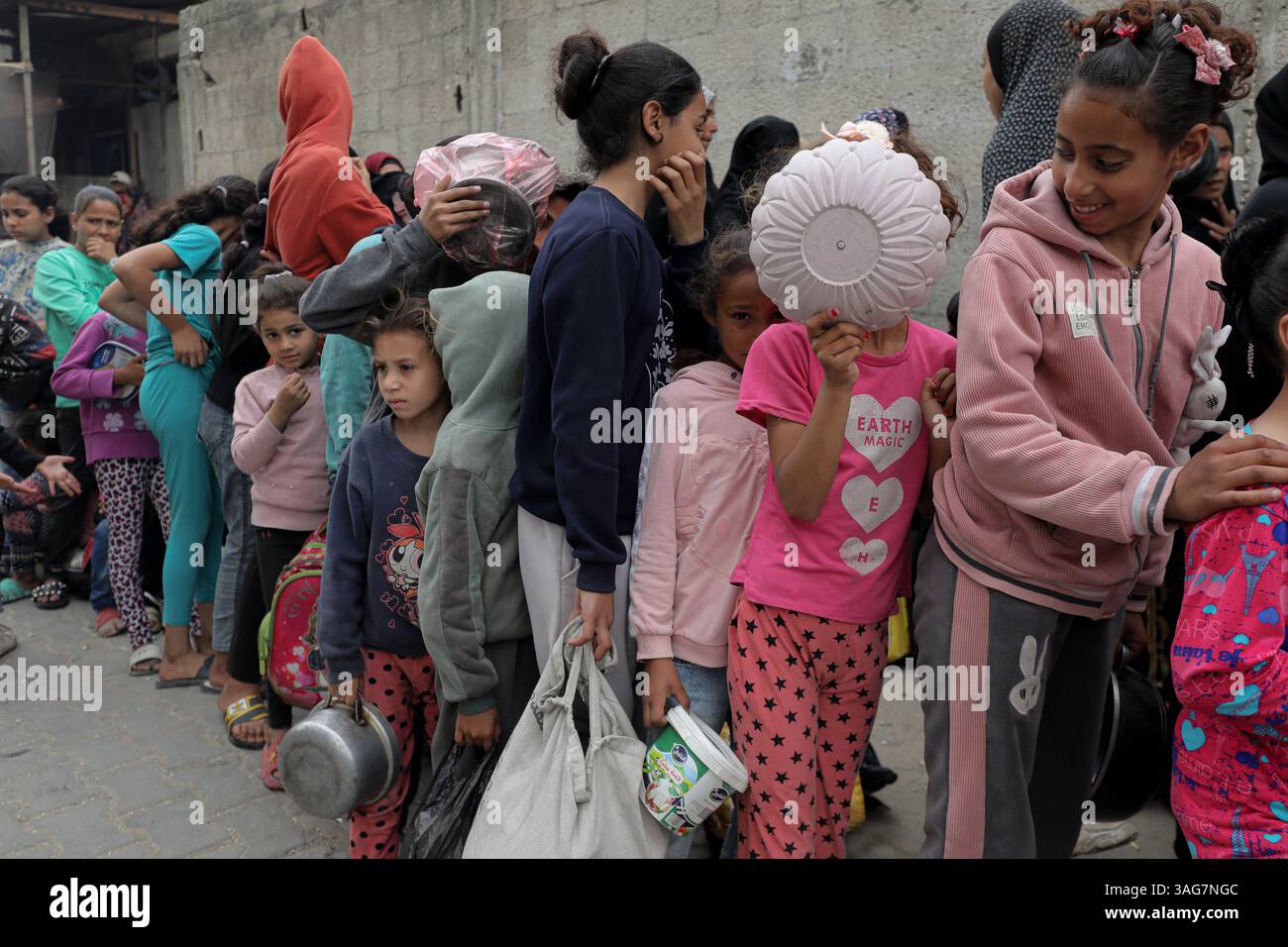 Palestinians gather in large numbers to receive the meals distributed ...
