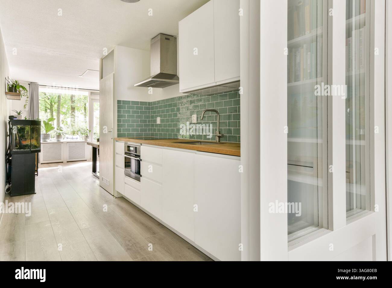 A sleek, modern kitchen featuring white cabinetry, wood accents, and ...