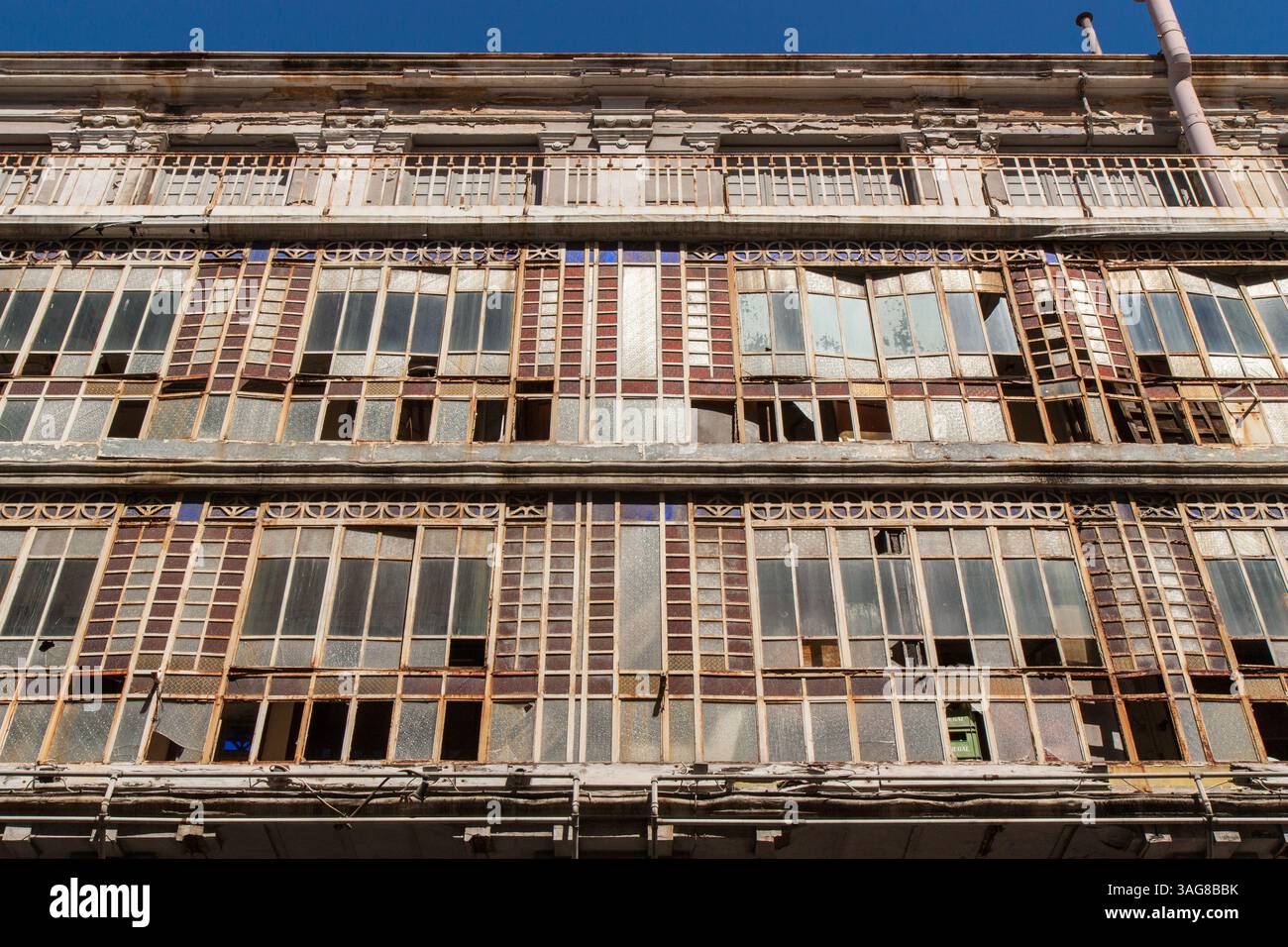 Old building facade with vintage glass windows and rusty frames in ...