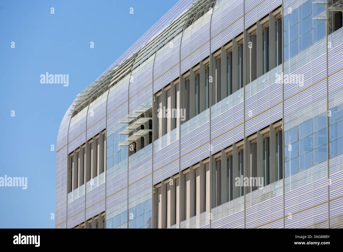 Modern building facade with glass windows and metal stripes reflecting ...