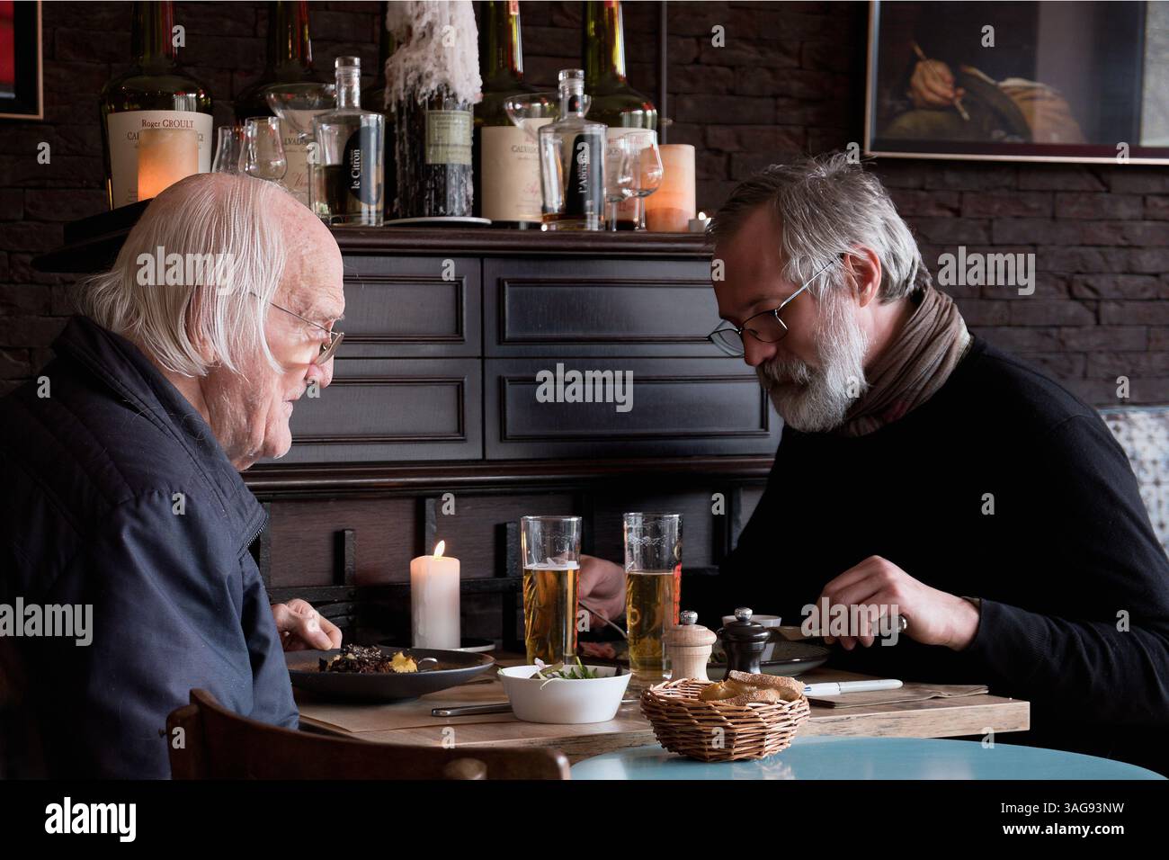 Elderly father and son eating in a small bistro in Paris in Spring ...