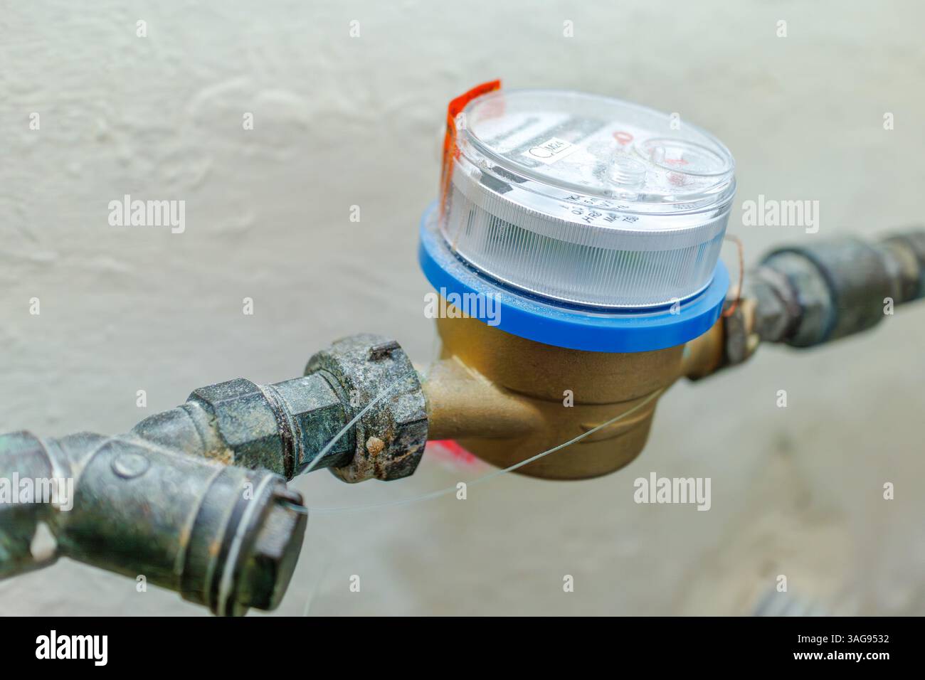Detailed view of a household water meter with connected pipes, showing ...