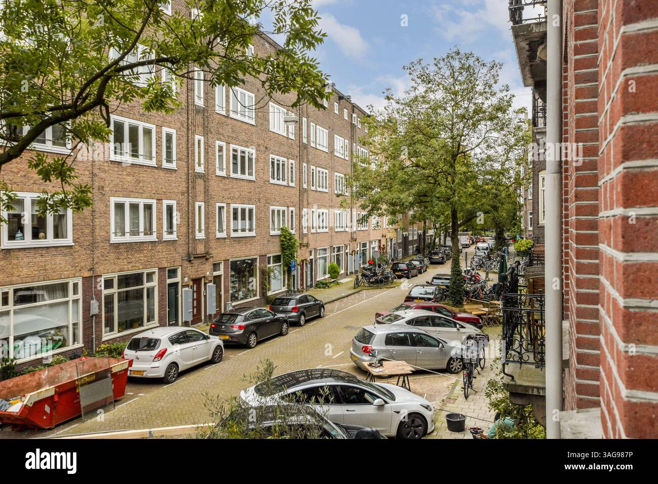 A picturesque city street lined with trees, featuring various parked ...