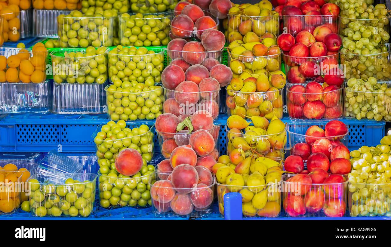 Colorful fresh fruit display at local market, peaches, plums, apples ...