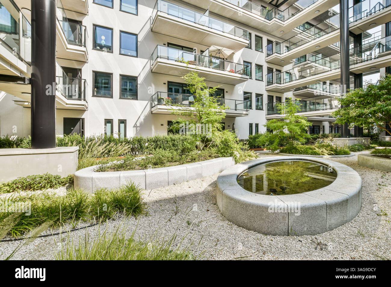A contemporary residential courtyard featuring greenery, water features ...
