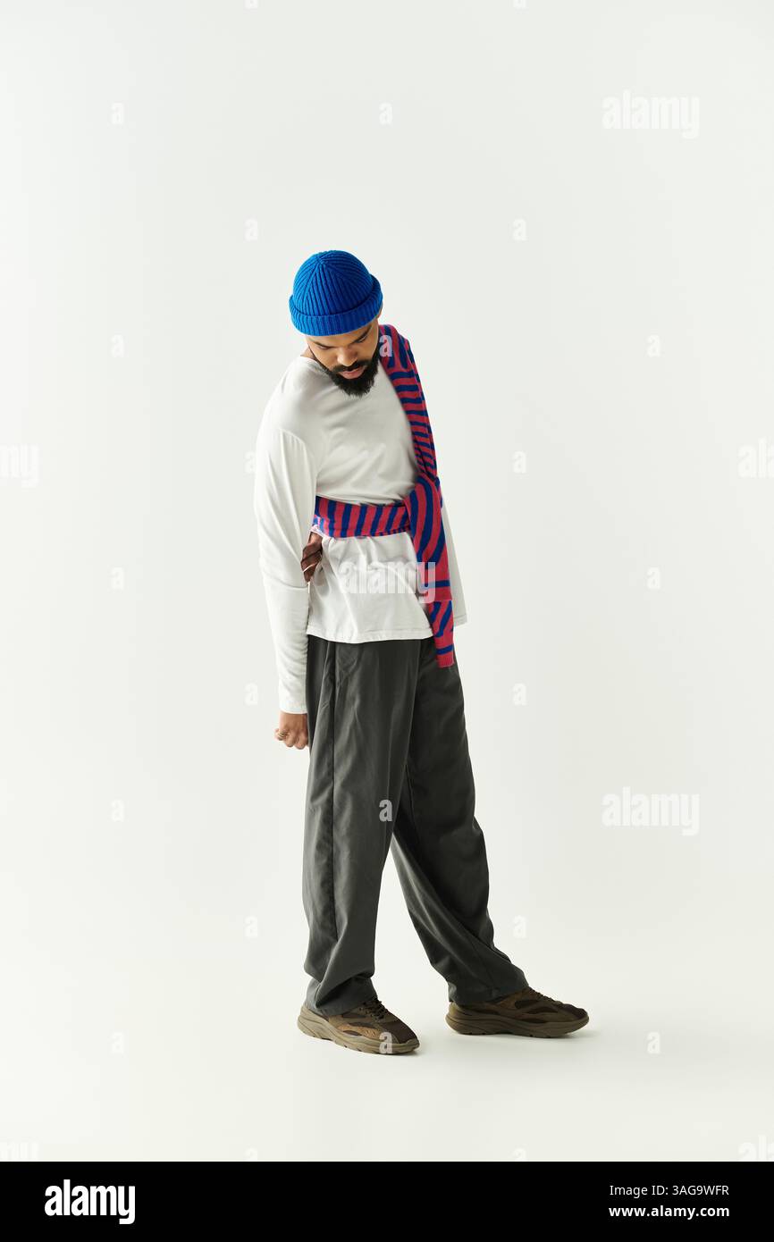 A stylish young man displays his trendy outfit in a calm, charming ...