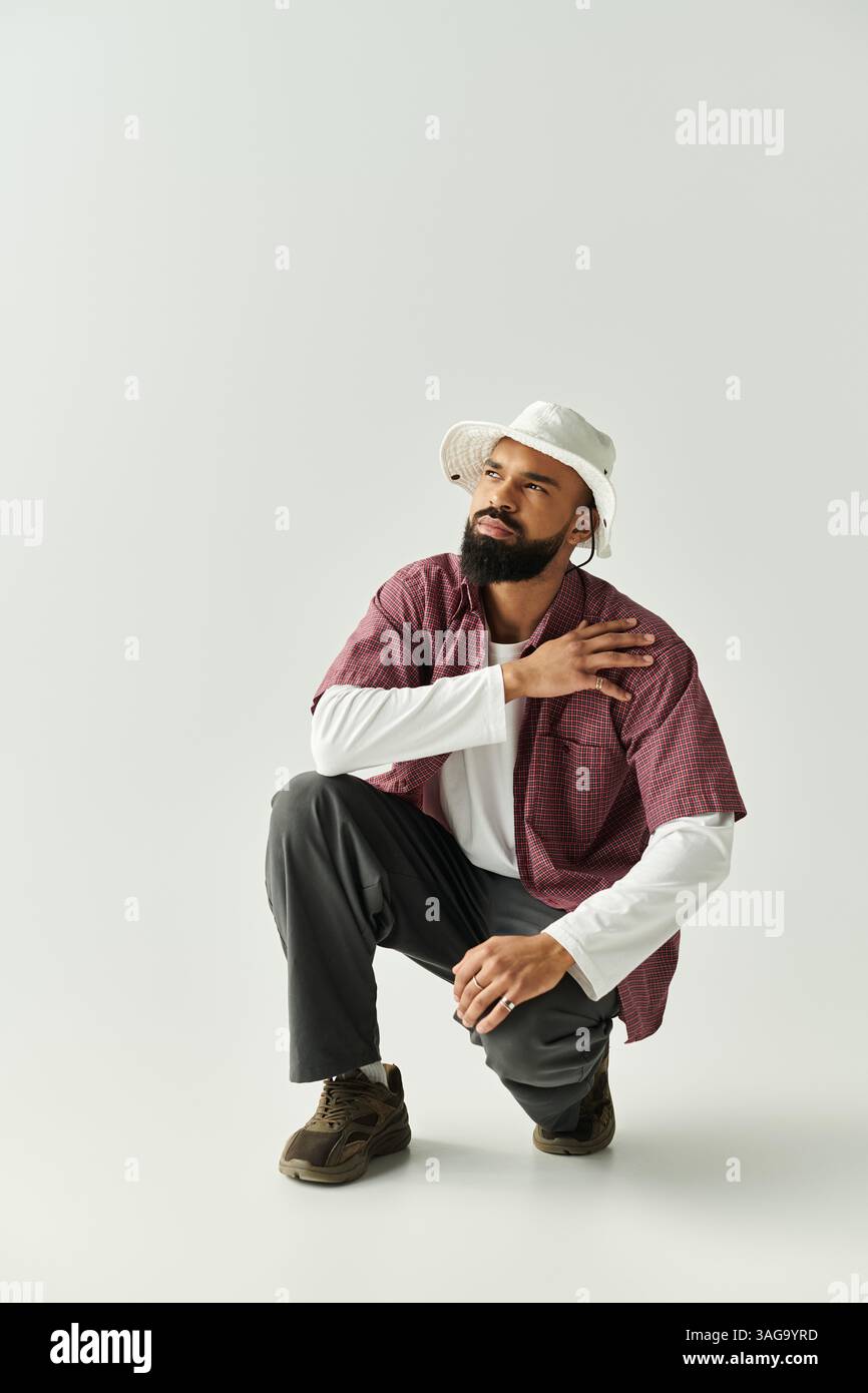 Handsome man showcases his fashion sense while squatting in a ...