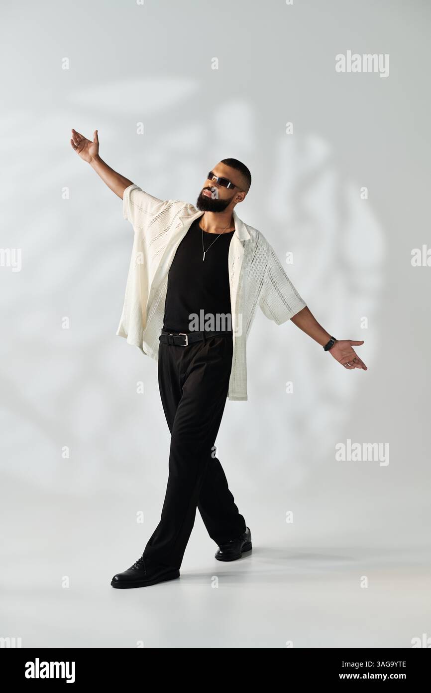 A young stylish man poses confidently in a sleek outfit, showcasing his ...