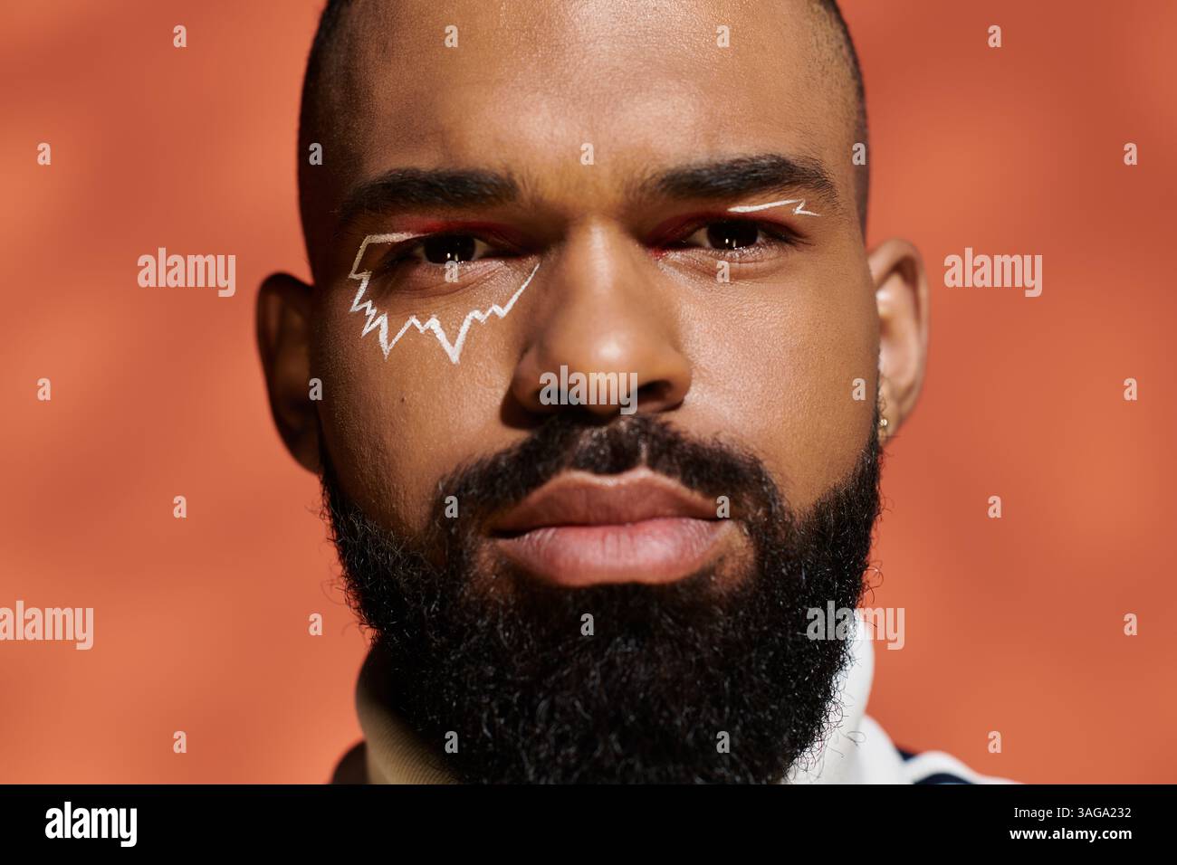 Young man with a bold style and striking facial art stands confidently ...