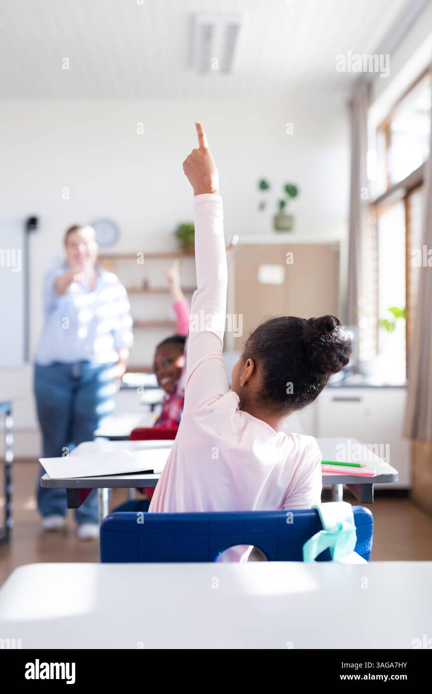 In school, girl raising hand to answer question in classroom Stock ...