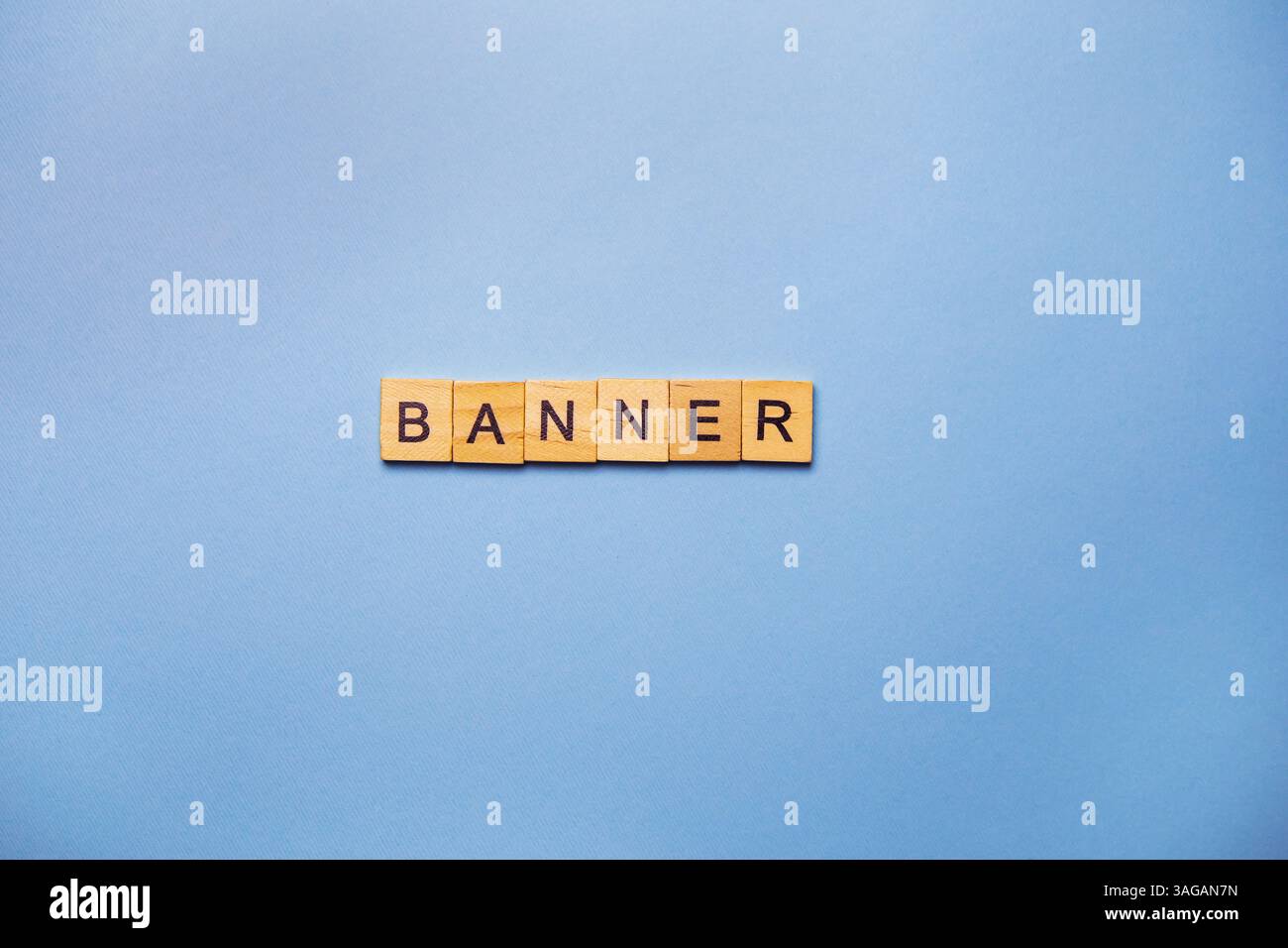 Wooden blocks spell out the word BANNER on a light blue background ...