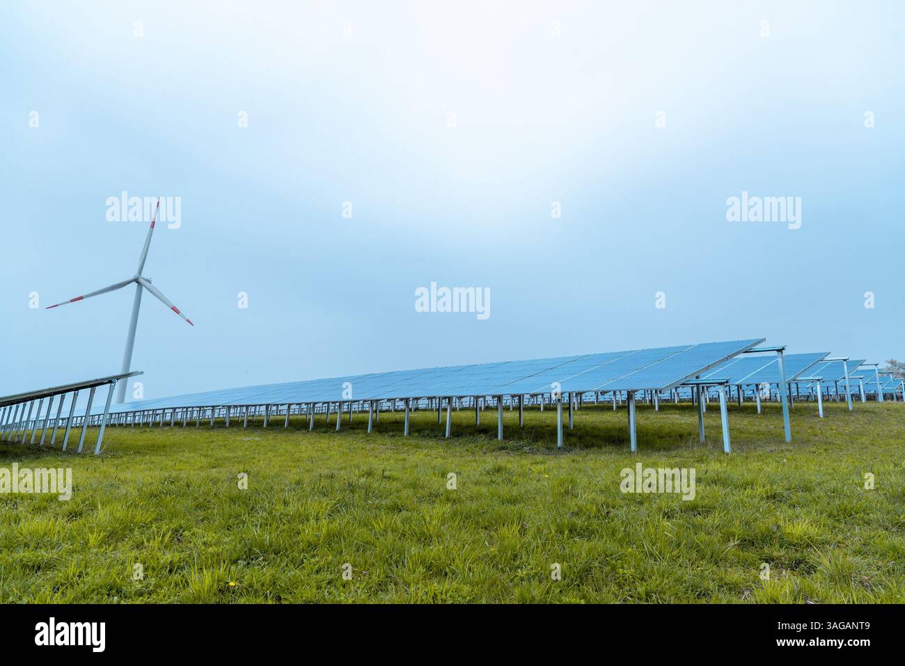 Solar panel farm and one wind turbine on a green field in Germany Stock ...