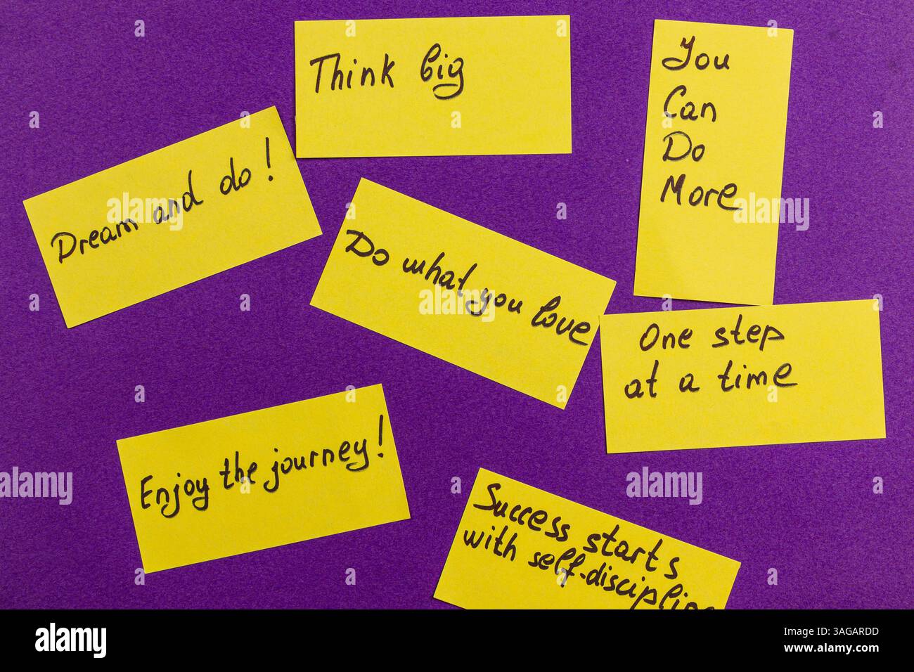 Colorful sticky notes with motivational phrases are arranged on a ...