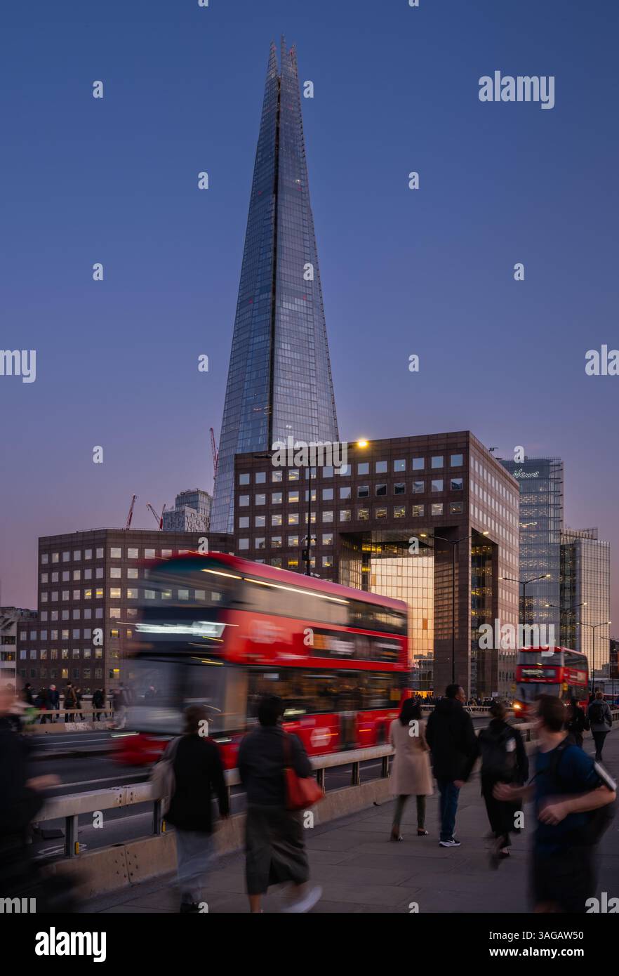 London, UK: Two red buses on London Bridge with movement blur at dusk ...