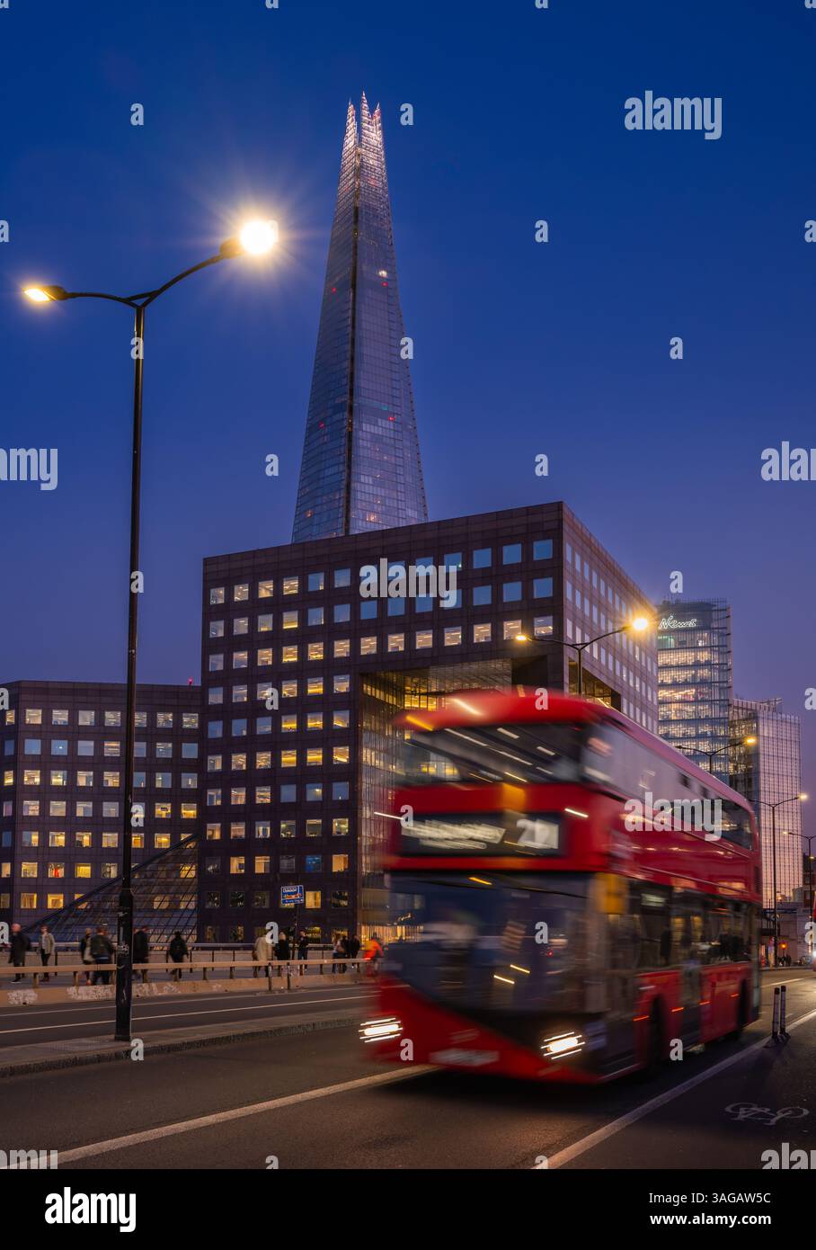 London, UK: Red bus on London Bridge with movement blur at dusk. The ...