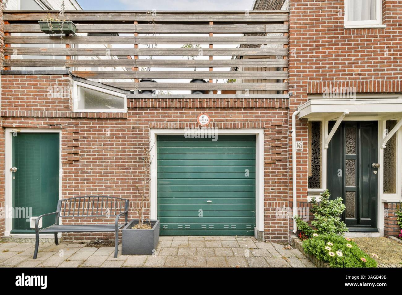 A picturesque brick house featuring green doors and a inviting porch ...