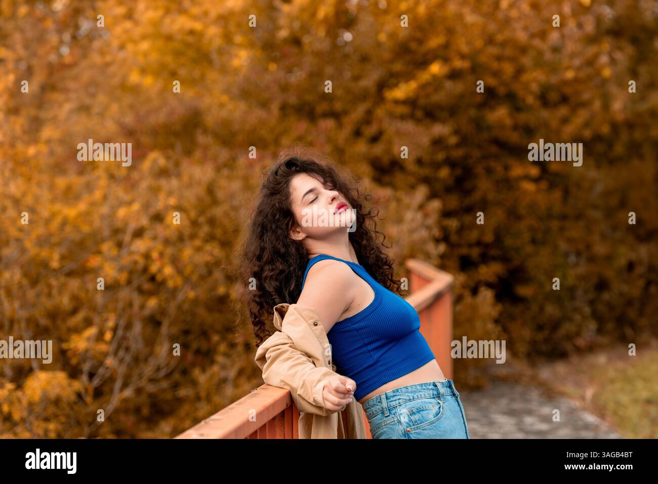 Carefree woman leaning on a rail with eyes closed and enjoys a ...