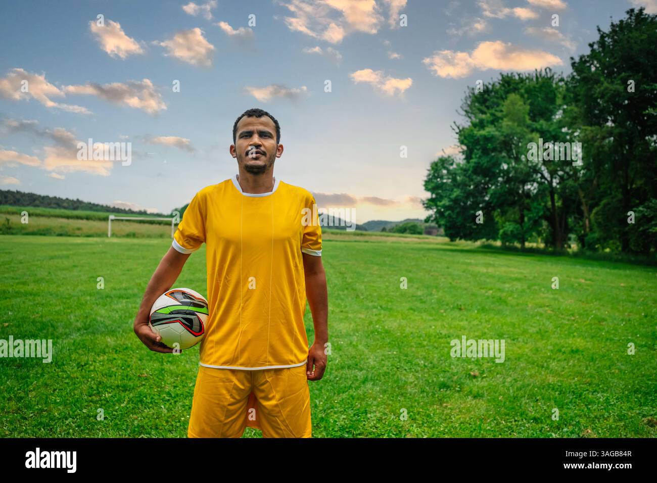 Portrait of young arab football player in outdoors football field ...